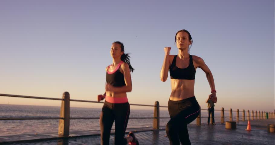 Two Athletic Woman Running Outdoors In Slow Motion On Promenade At ...