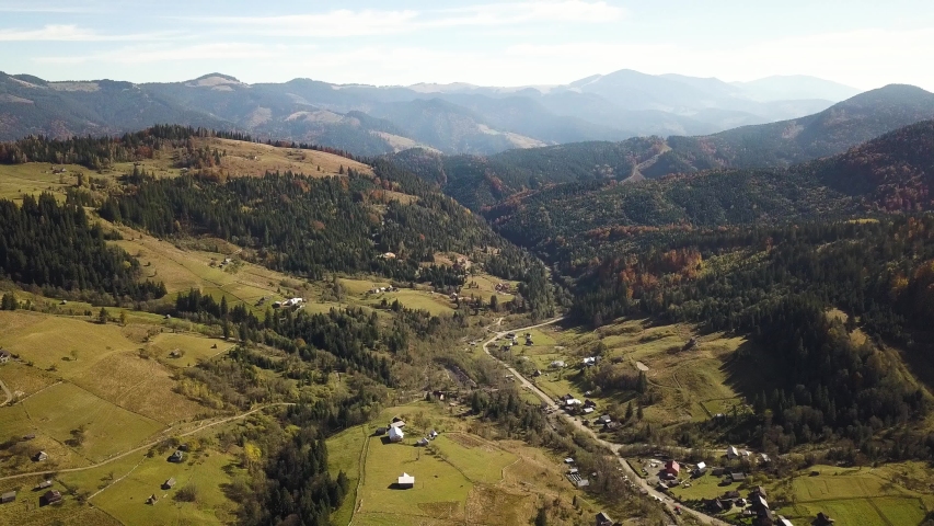 Landscape with houses, hills, and mountains in the distance image ...