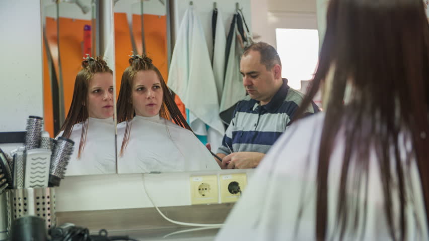Stock video of over shoulder mirror reflection of hairdresser ...