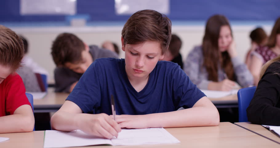 4k, Bored School Boy In A Classroom Drawing Doodles While Rest Of The ...