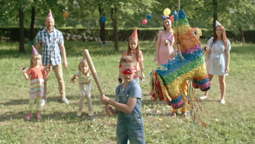 Excited Boy With Blindfold Hitting Pinata With Wooden Bat While Playing ...