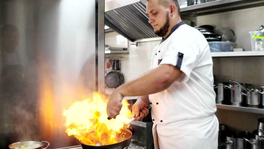 Stock video of chef pouring alcohol into pan ignites, | 21220219 ...