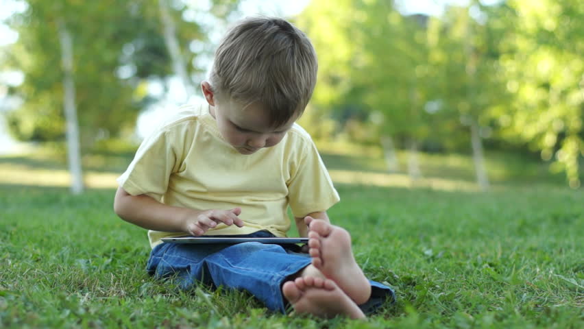 Stock Video Clip of Little boy using a tablet pc outdoors | Shutterstock