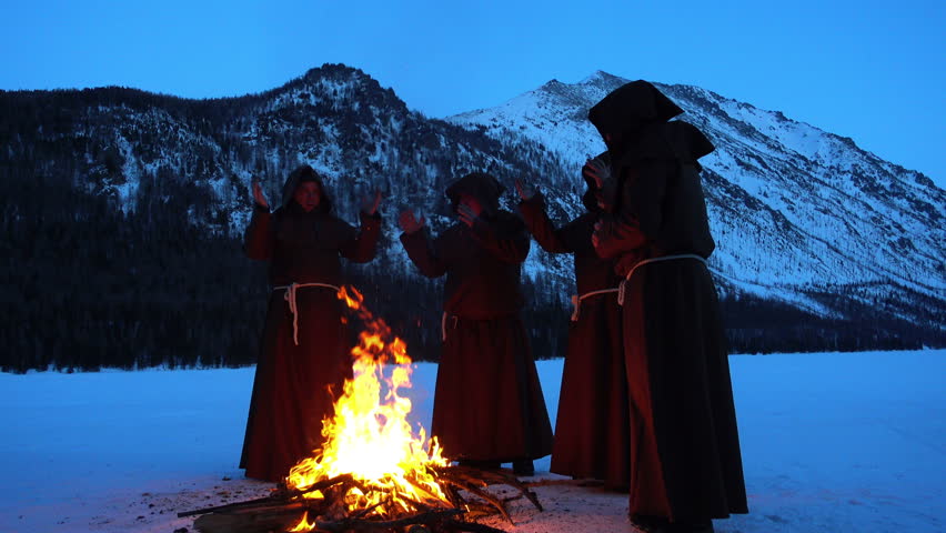 Stock Video Clip of Four monks pray at the campfire in | Shutterstock