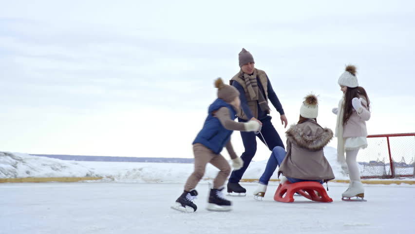 Tracking Of Little Children And Young Man Skating On Outdoor Ice Rink ...