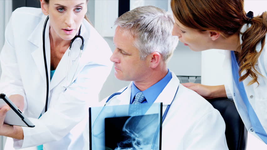 Caucasian Male Medical Consultant With Young Female Doctor Updating ...