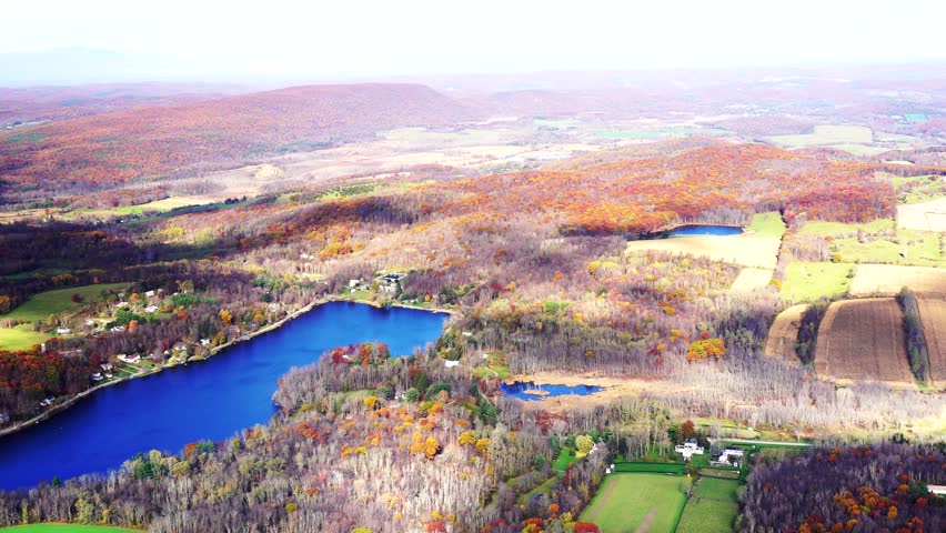 Flying Above Blue Alpine Lake Towards Shore With Boat House And ...
