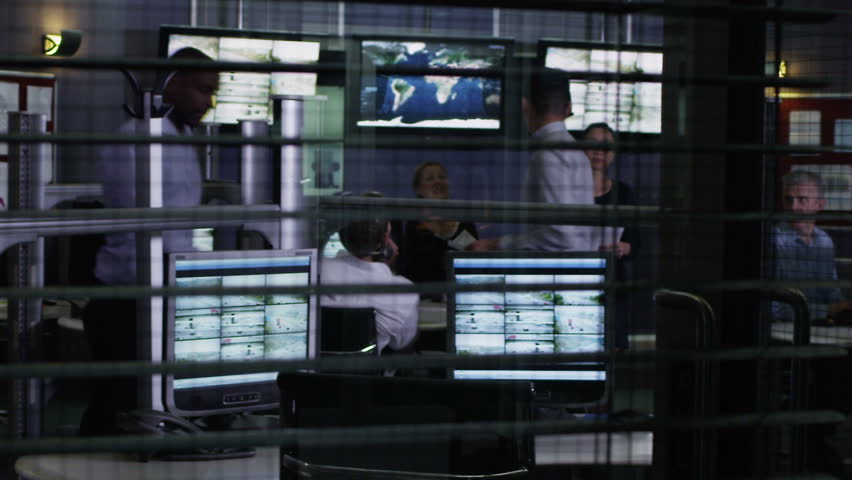 Team Of Security Personnel Watching The Screens In A System Control ...