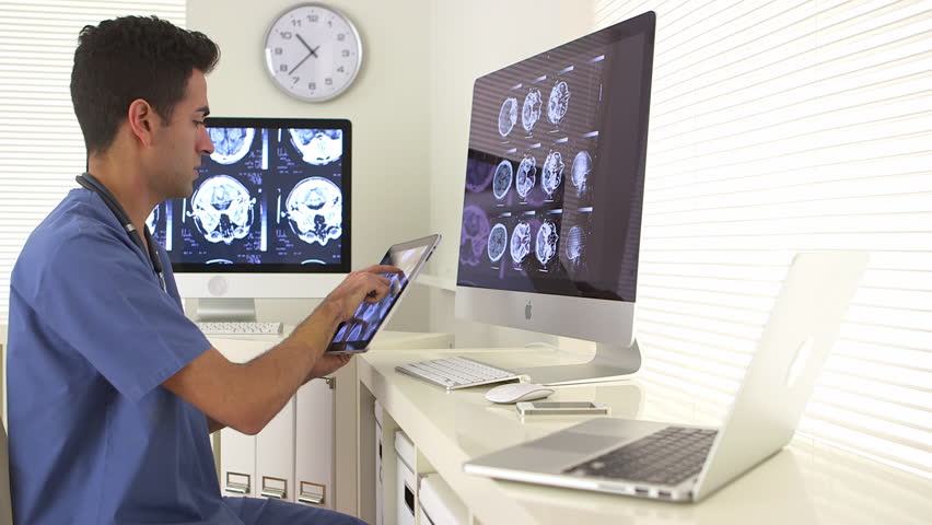 Doctor Looking At Computer Screen While Patient Moving In Mri Machine ...