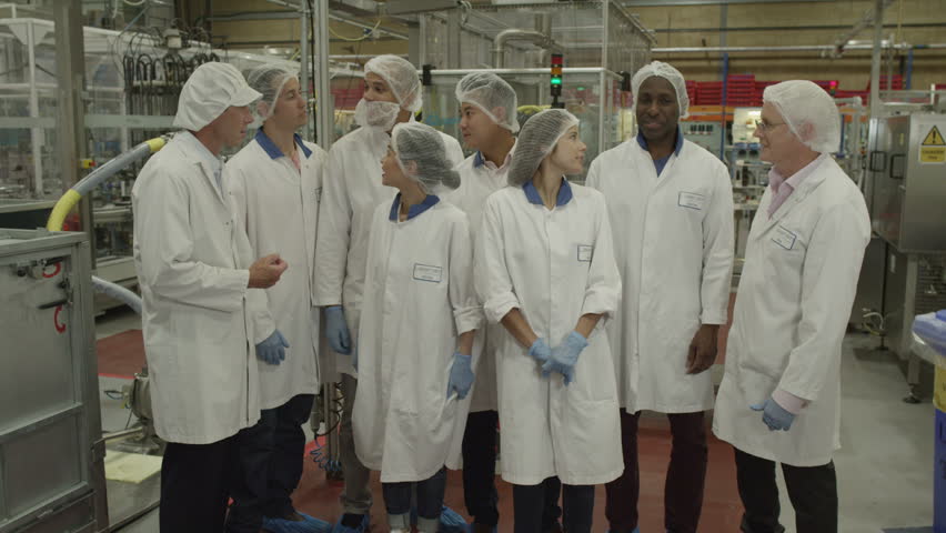 4K Production Facility Team Staff Together On Factory Floor. Smiling ...